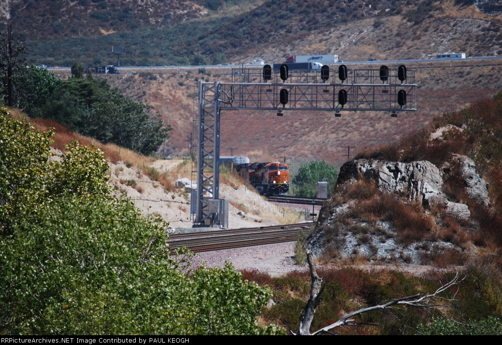 BNSF 7912 peaks her nose out as she rounds the bottom end of a curve rolling west/south towards ...